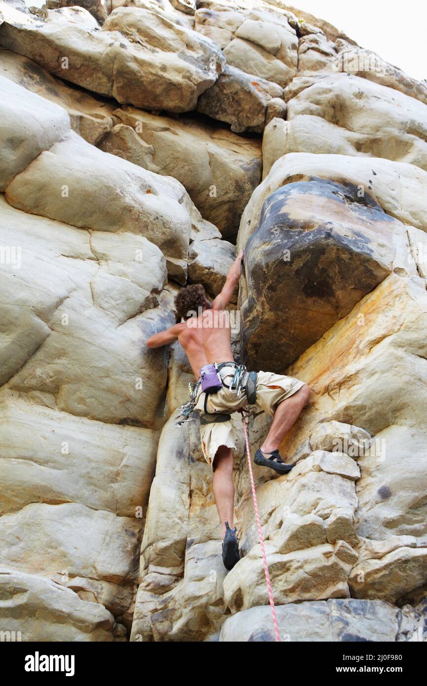 Getting to the top. A rock climber climbing up a cliff face Stock Photo ...