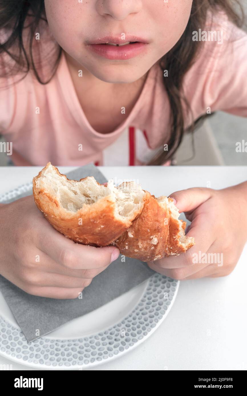 Young girl eat croissant Stock Photo - Alamy