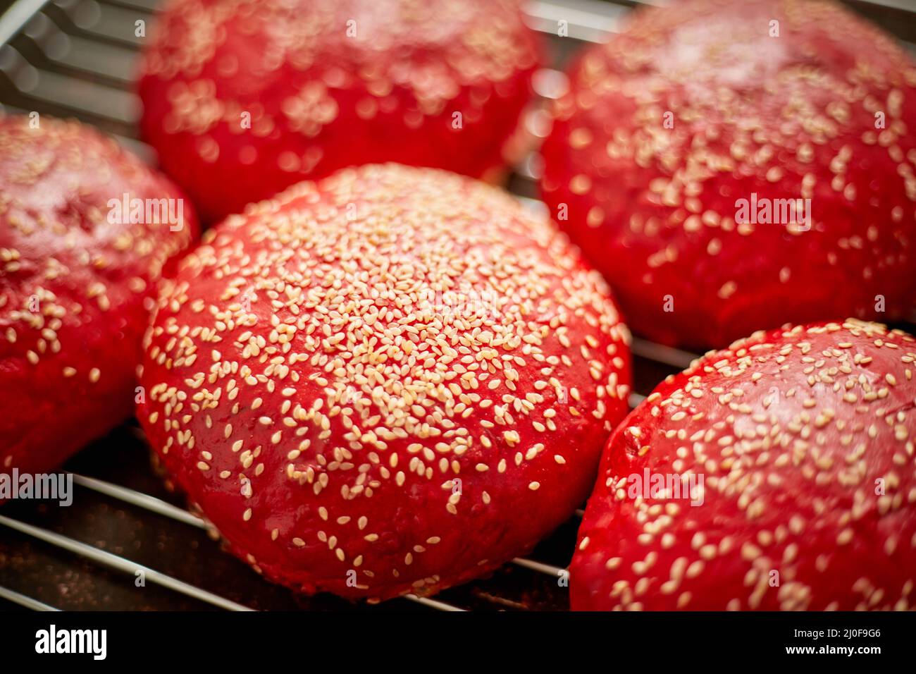 Fresh baked red homemade burger buns with sesame top view. Placed on ...