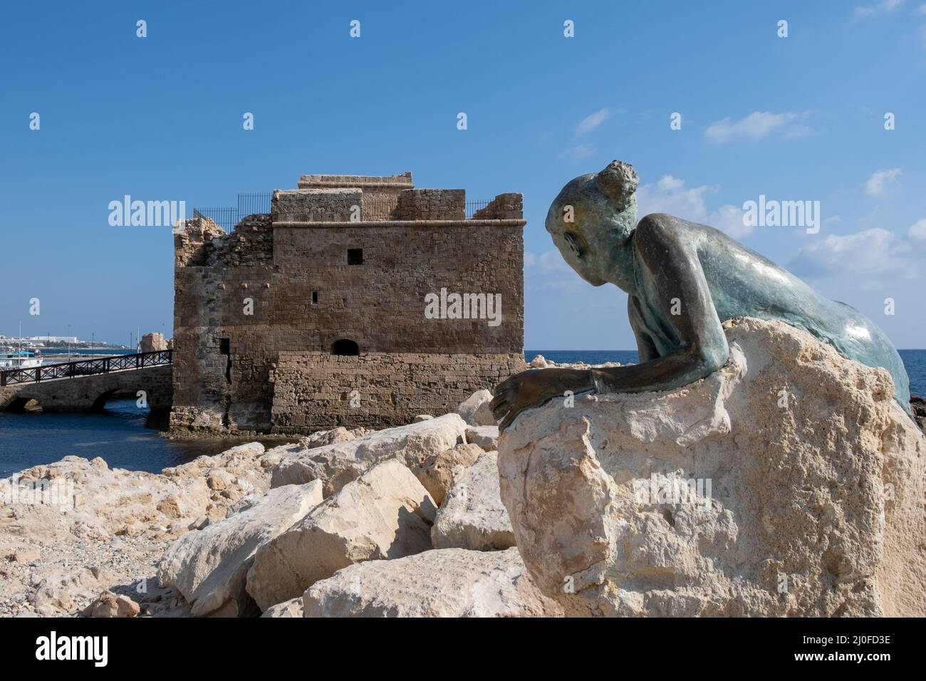 Bronze statue of woman on a stone looking at the castle. Paphos Cyprus ...