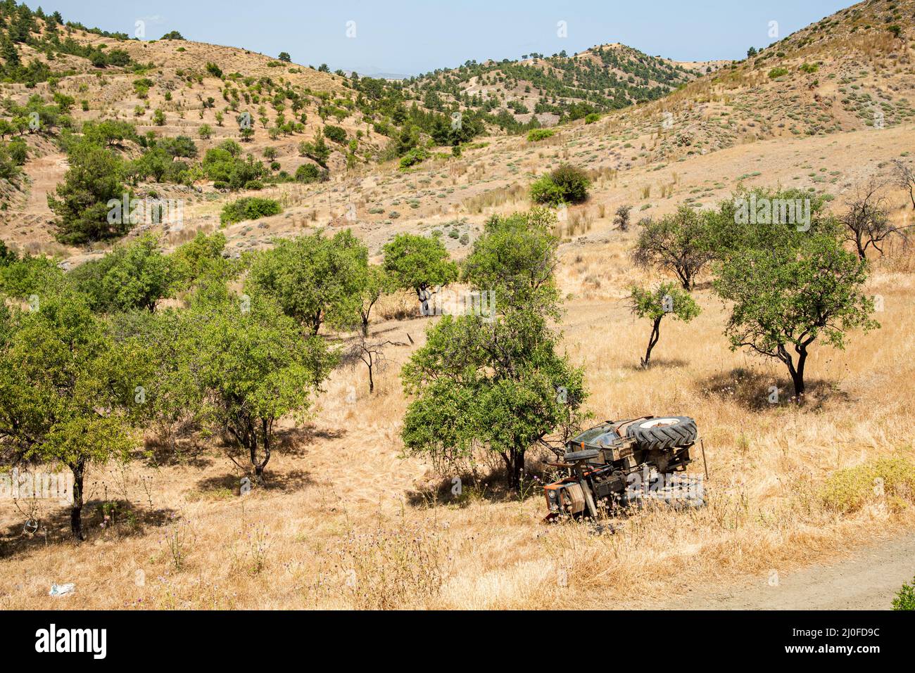 Farm tractor lay into the rural field with trees after accident Stock ...