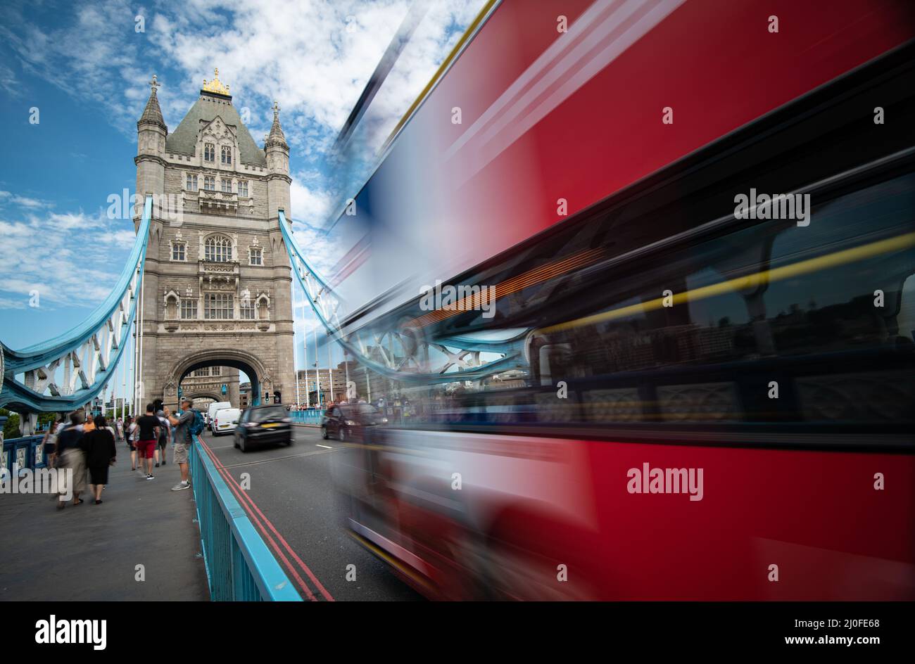 People walking and red traditional London bus crossing the famous ...