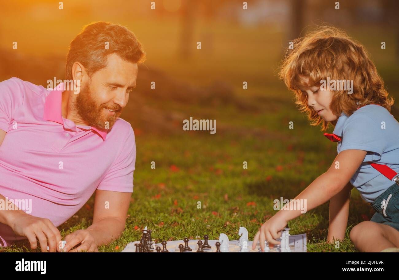Father and son playing chess spending time together outdoor. Men like ...