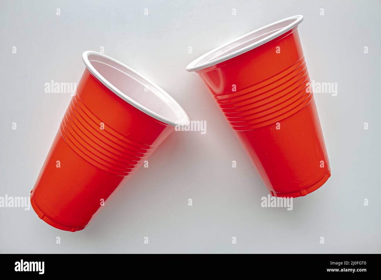 Close up to single use red plastic glass on a white background. Concept ...