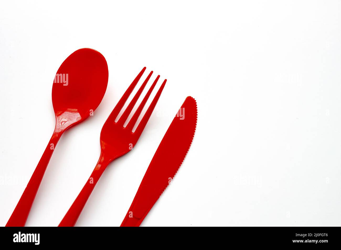 Close up to single use red plastic cutlery on a white background ...