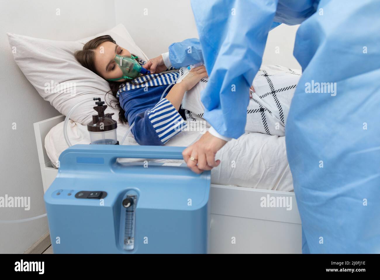 The doctor regulates the respirator so that the patient has the right ...