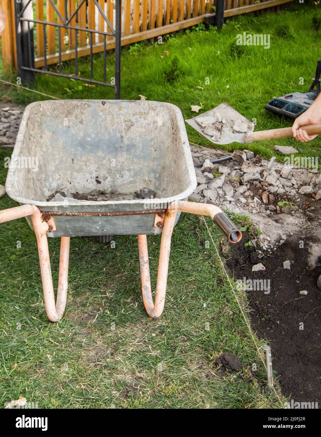 An empty old rusty wheelbarrow for the removal of soil during the ...