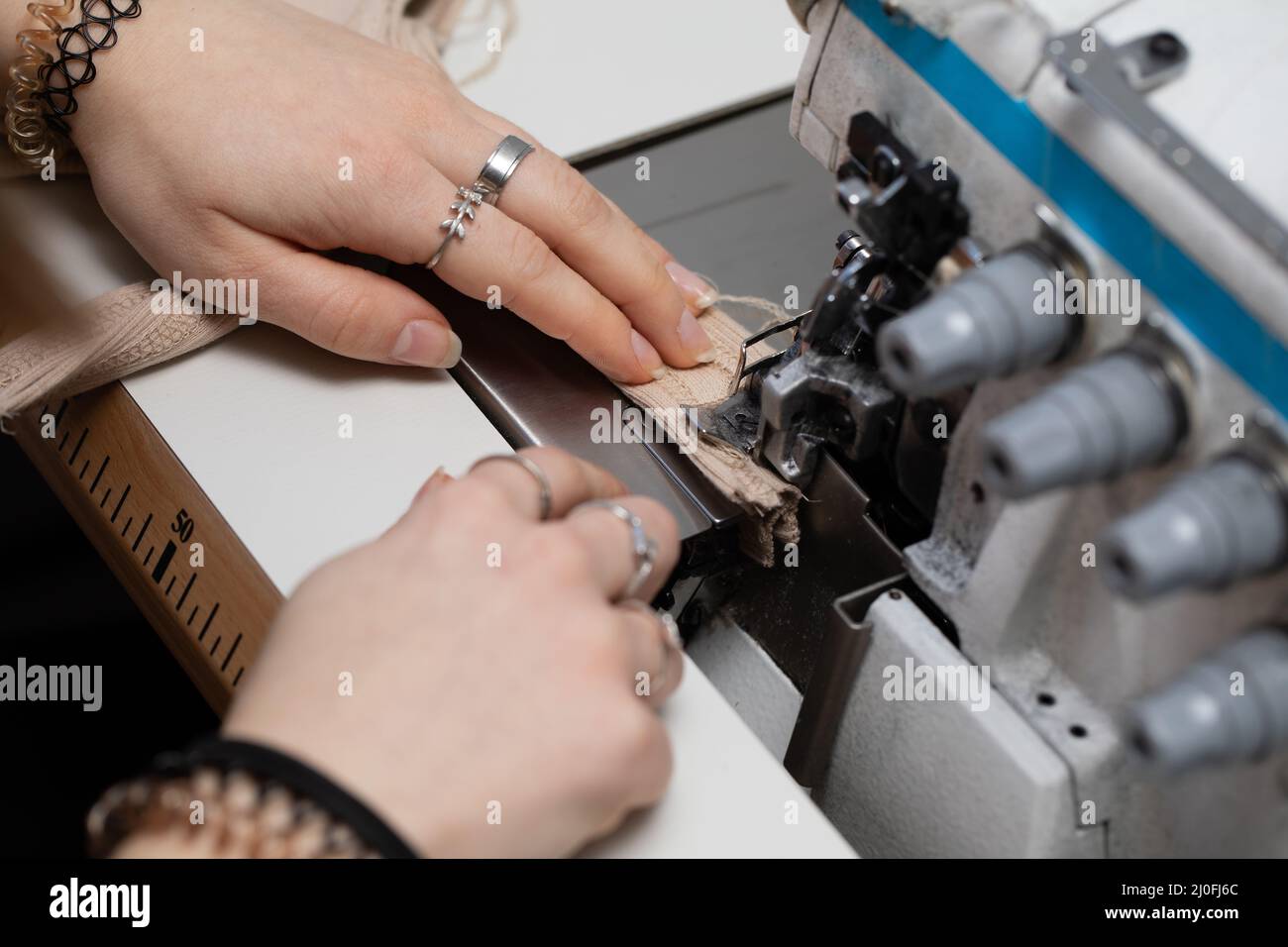 A close up shot of how a young dressmaker sews a shoulder strap of ...