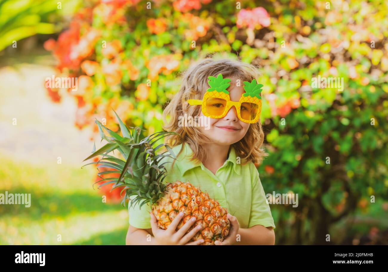 Young boy holding pineapple and smiling outdoor Stock Photo - Alamy