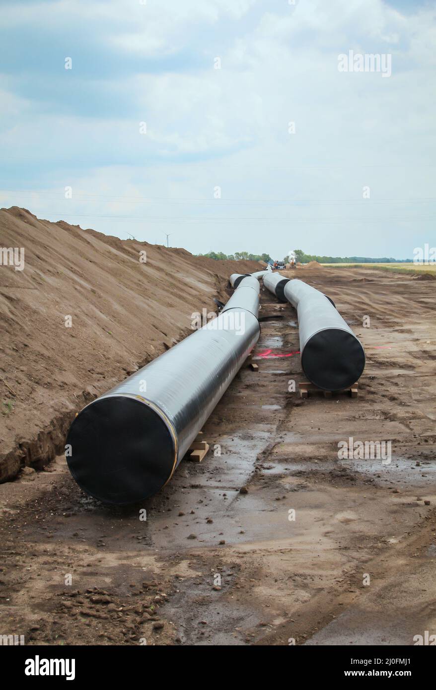 Pipes for a new pipeline for the water supply lie in a field Stock ...