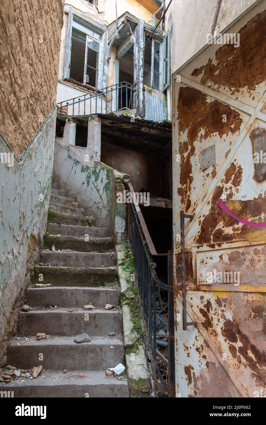 Damaged concrete stairs leading to an a collapsing house Stock Photo ...