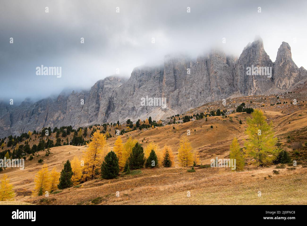 Dolomite mountain peaks covered in fog during sunrise Stock Photo - Alamy