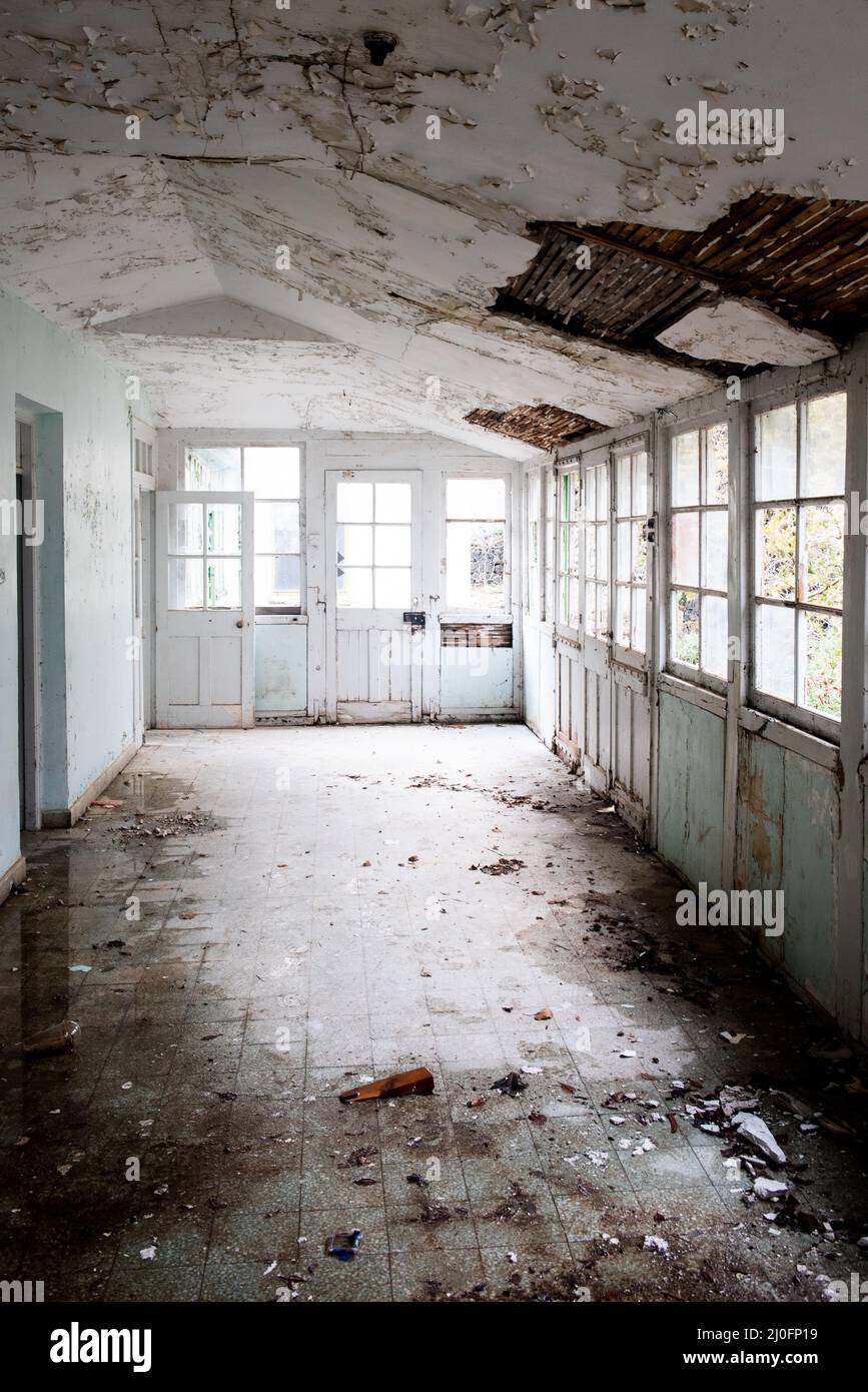 Interior corridor of an abandoned hospital with collapsing roof and ...