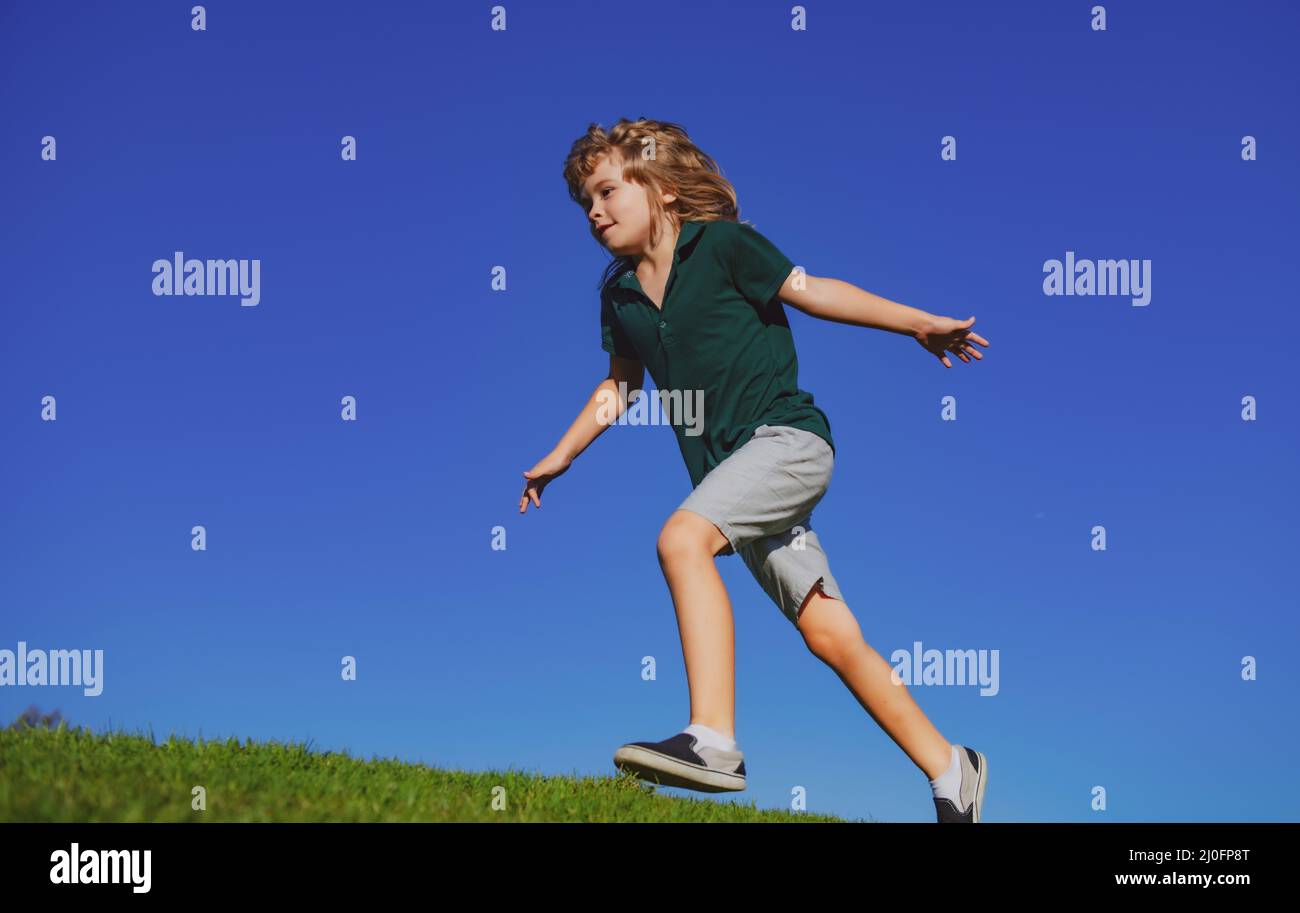Child boy running on grass field and dreaming. Kids play on summer ...