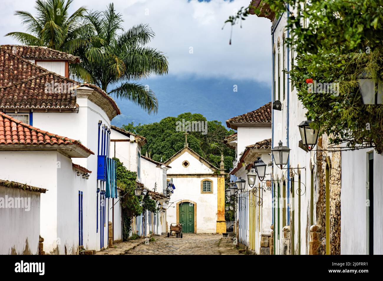 Street with its lanterns, colonial style houses, cobblestone pavement ...