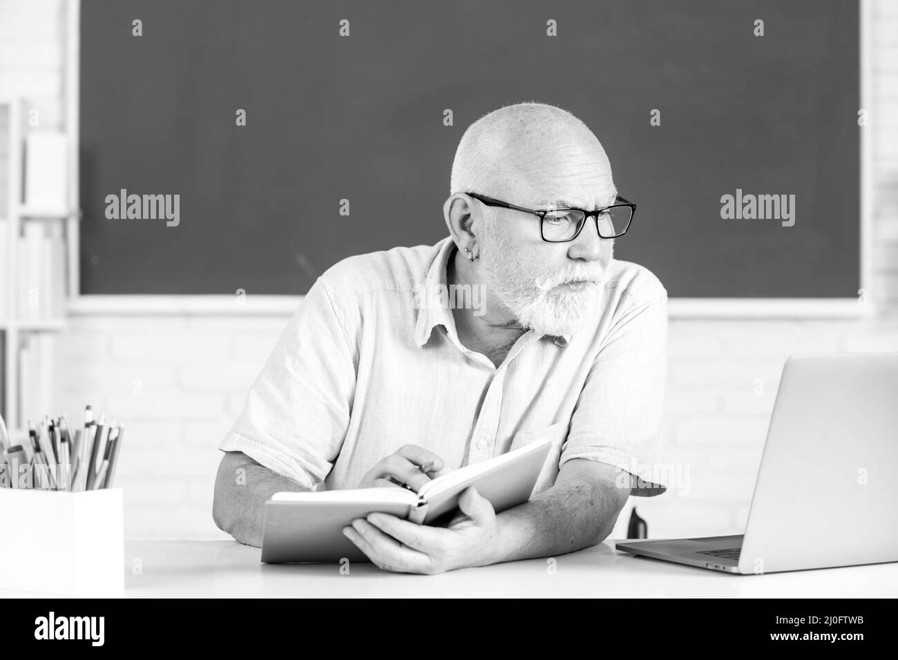 Portrait of confident caucasian senior teacher in classroom. Adult ...