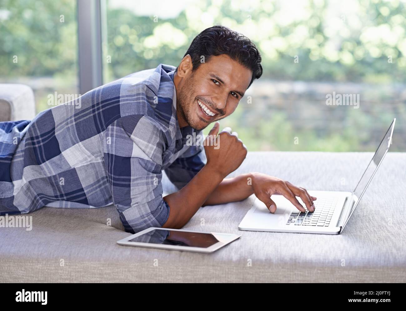 Connected to the world wide web. A young man using his laptop with his ...