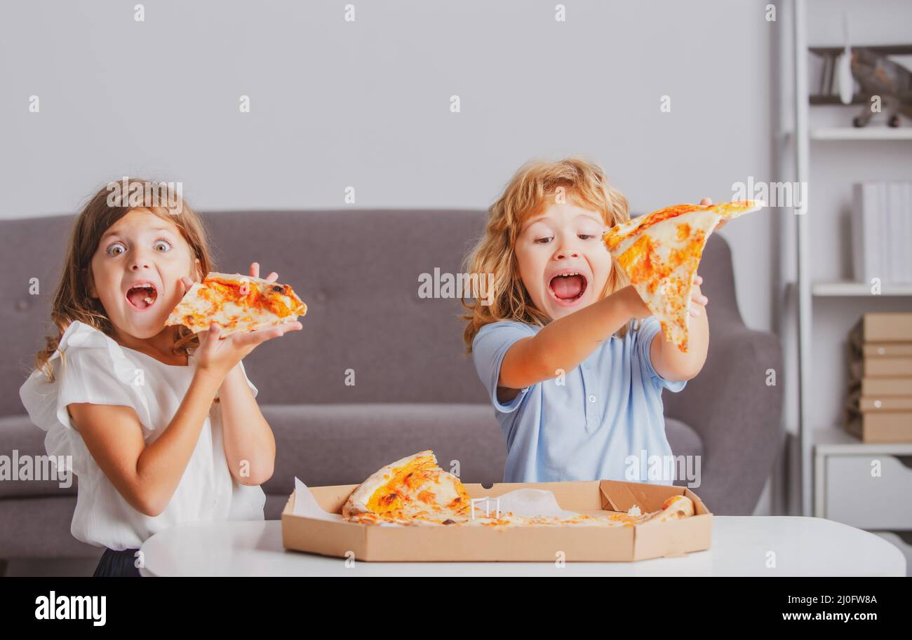 Children eating pizza. Excited kids eating pizza. Two young children ...