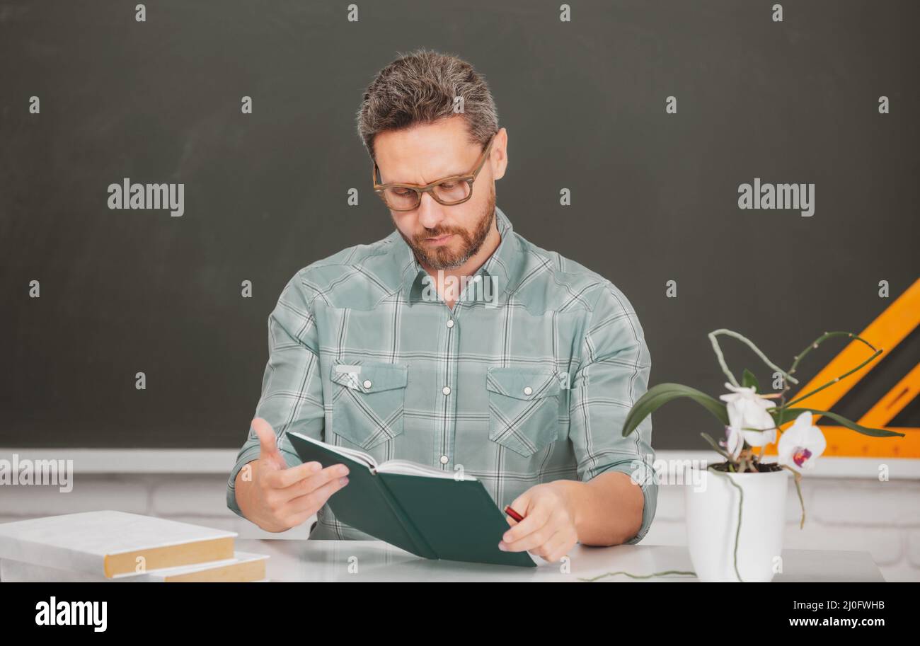 Portrait of male teacher teaching line of high school students with ...