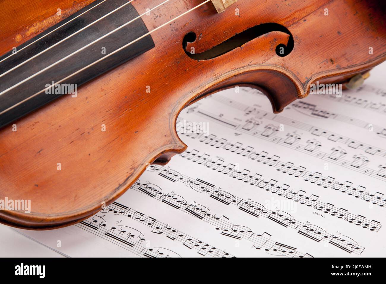 Let the music begin. Cropped shot of a violin lying atop sheet music ...