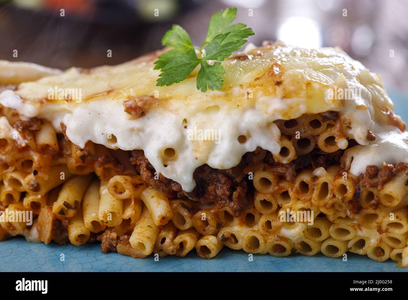 Greek pastitsio on a blue plate Stock Photo - Alamy