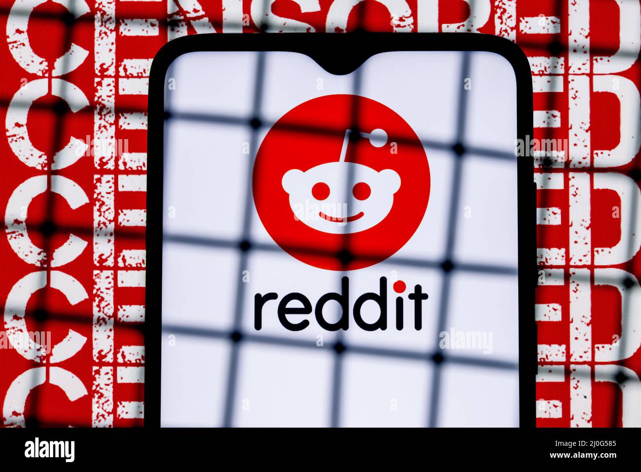 Reddit discussion platform logo on the smartphone screen behind the ...