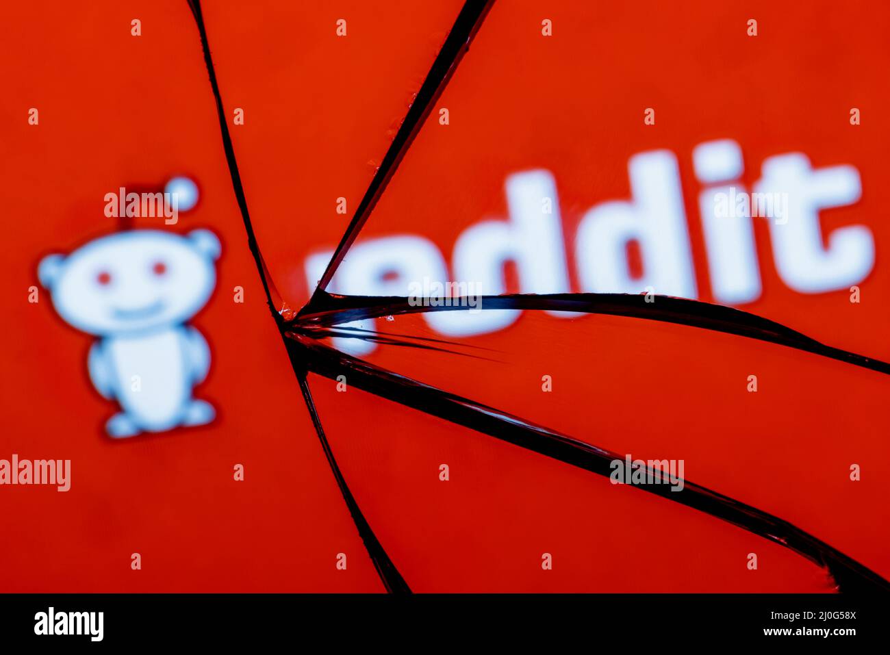 Logo of the Reddit discussion platform in the reflection of a broken ...