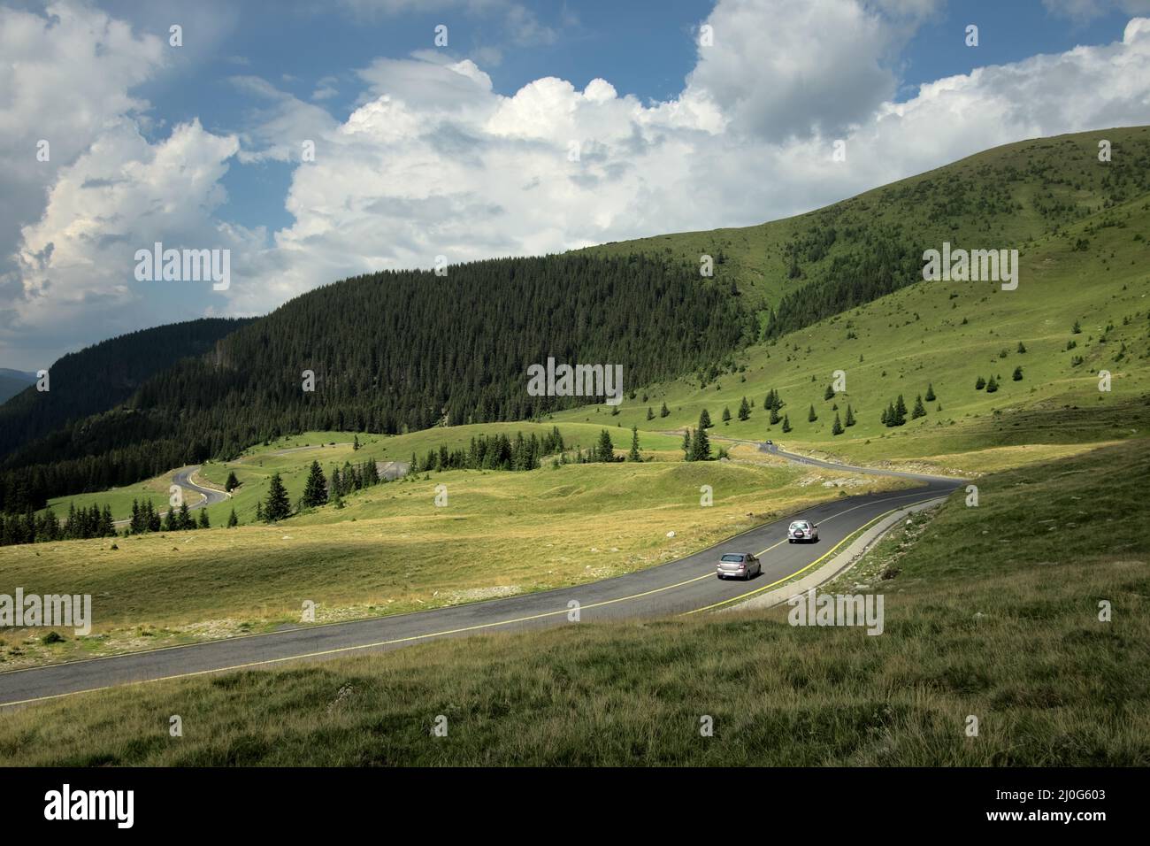 car is driving on road in an alpine landscape of a roadtrip in Romania ...