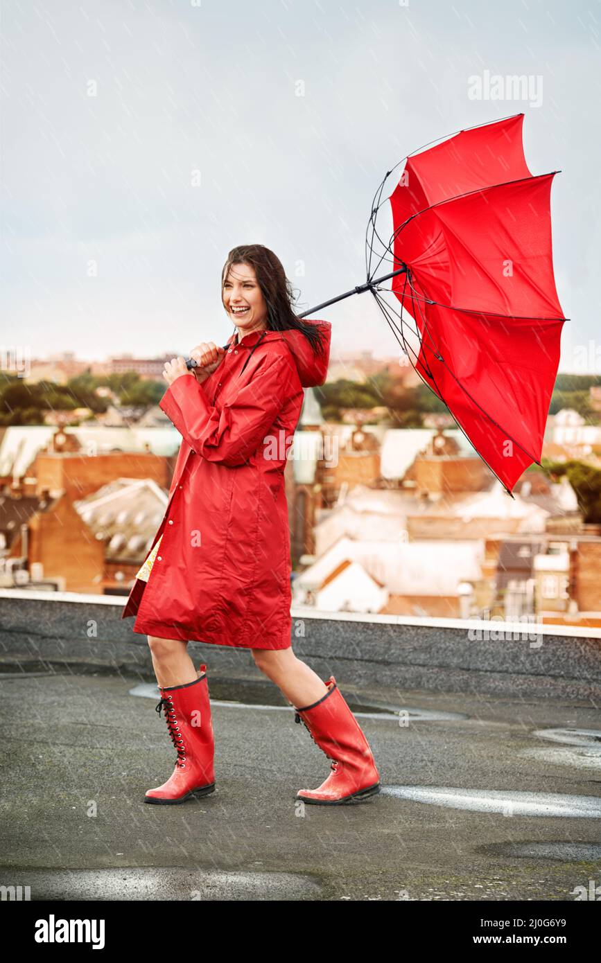 Facing the storm with a smile. Young woman laughing while being ...