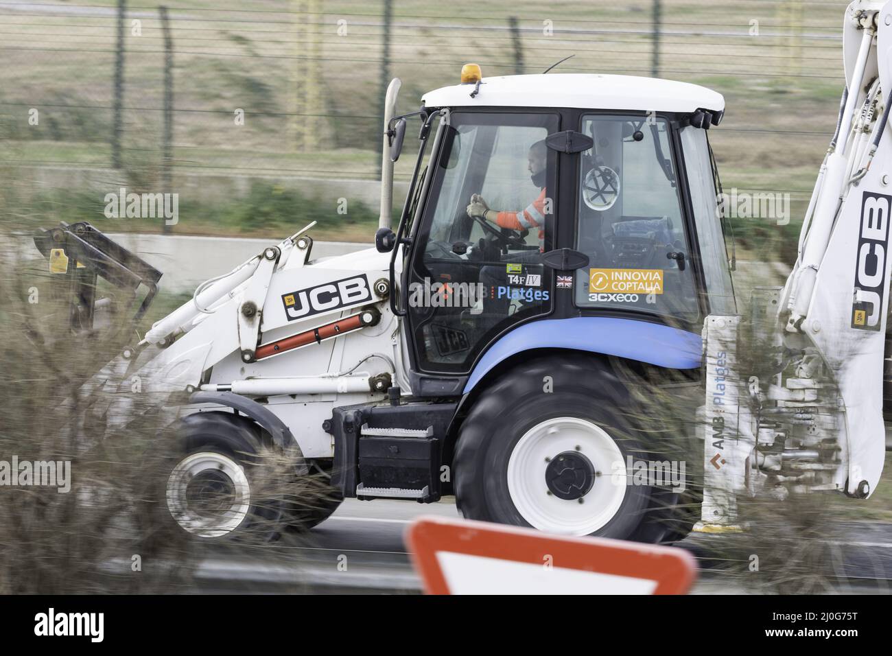 White and blue tractor working in the city, JCB model 3CX Stock Photo ...