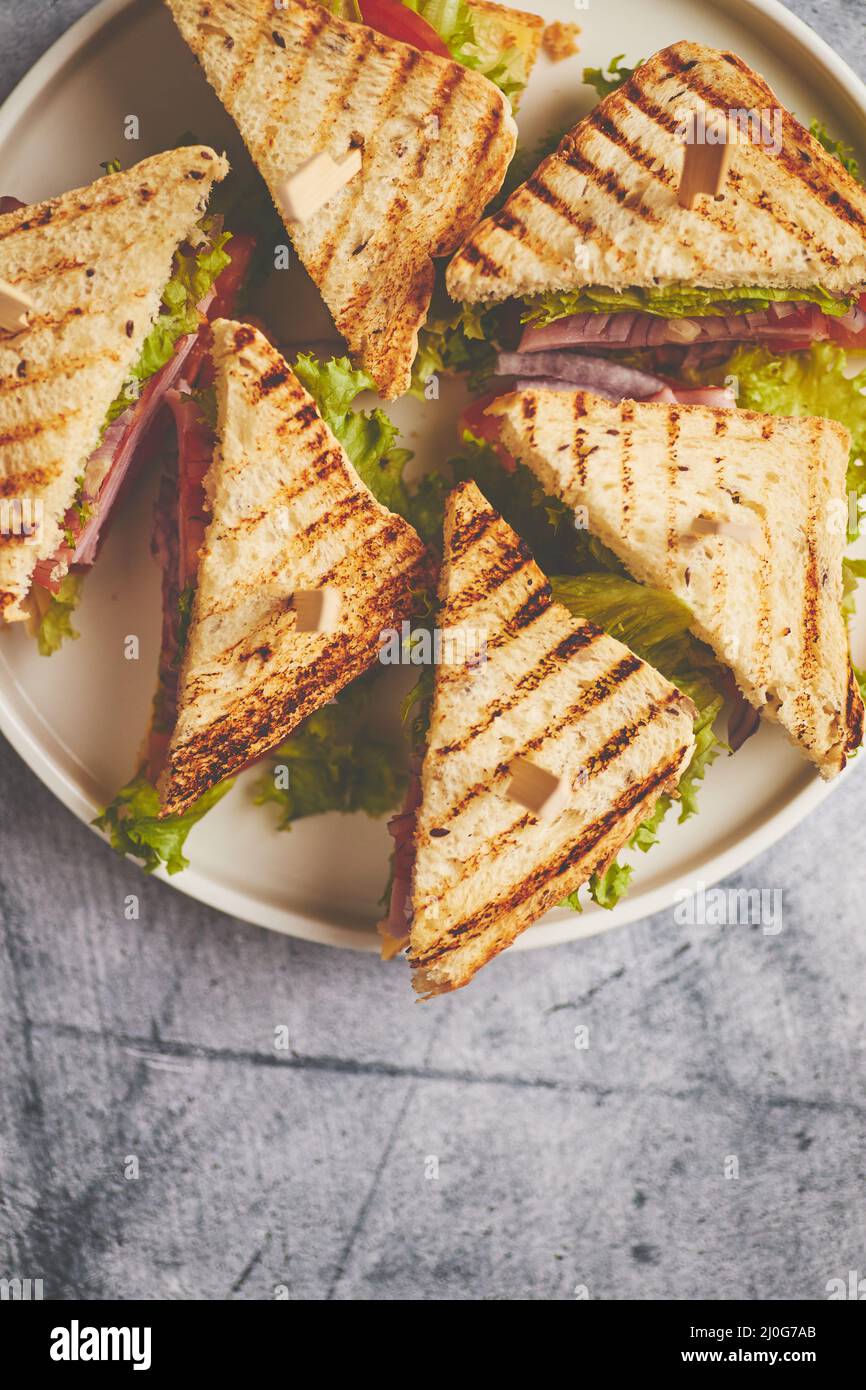 Club sandwich on toasted white bread with a meat filling served with ...