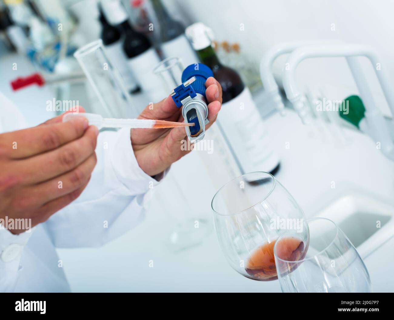 Close up on hands testing wine quality in lab Stock Photo - Alamy