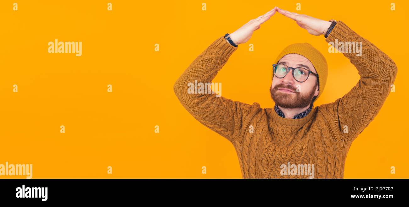 Portrait of handsome Caucasian man looking up holding arms above his ...
