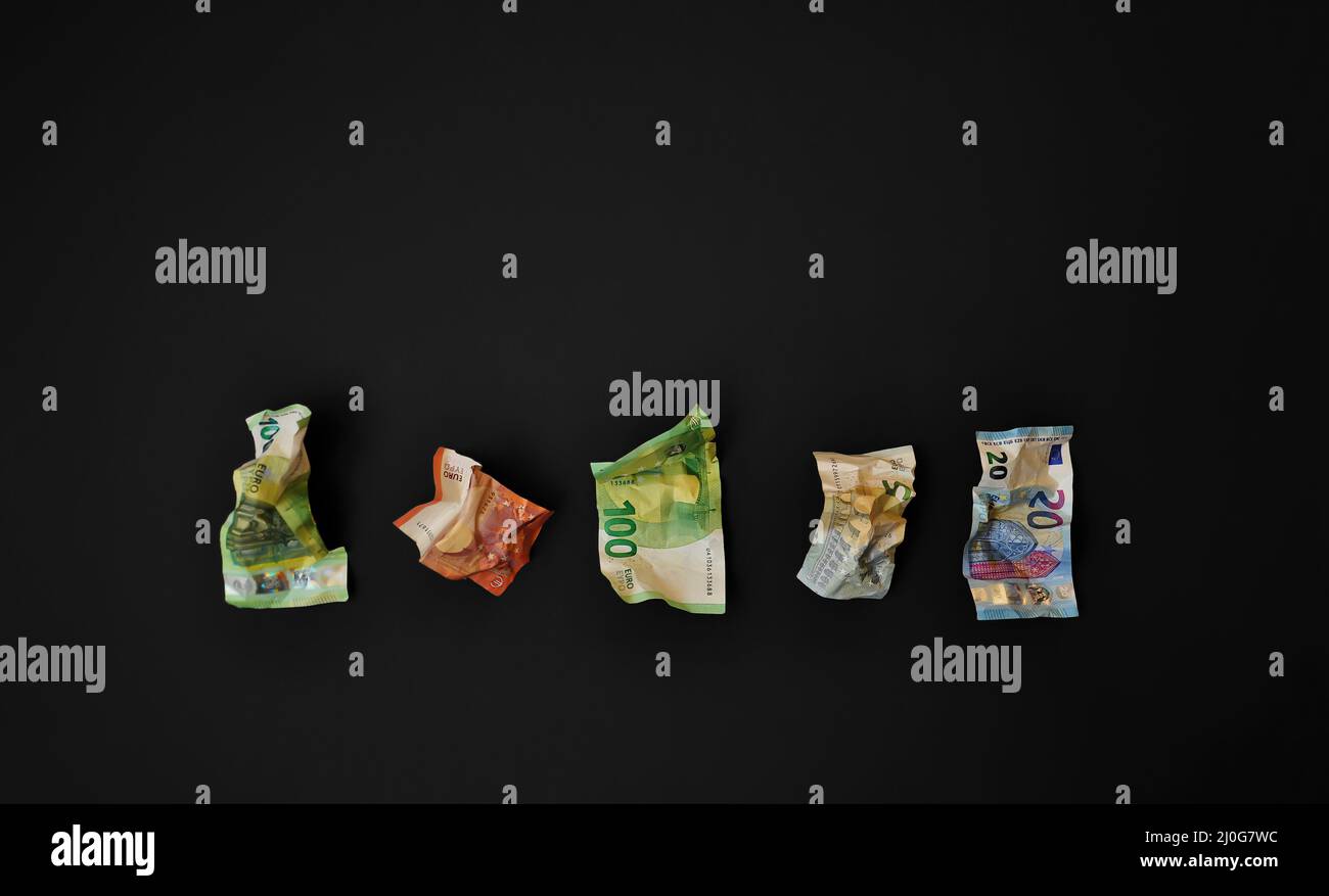 A pile of crumpled euro banknotes on a black background. Minimalism ...