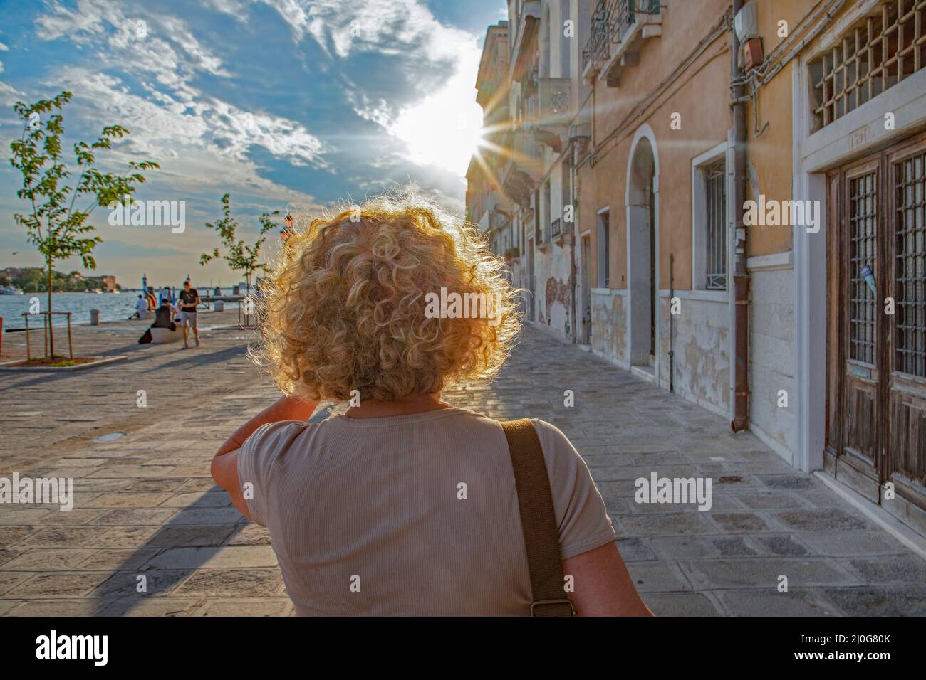 attractive woman with golden hair walks along the scenic promenade in ...
