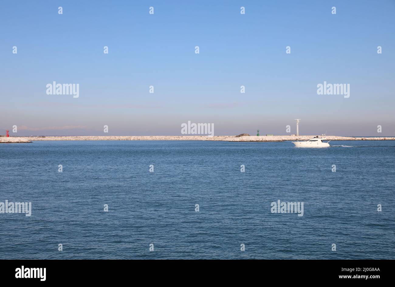 boat in the middle of the sea and a long protective dam near Venice ...