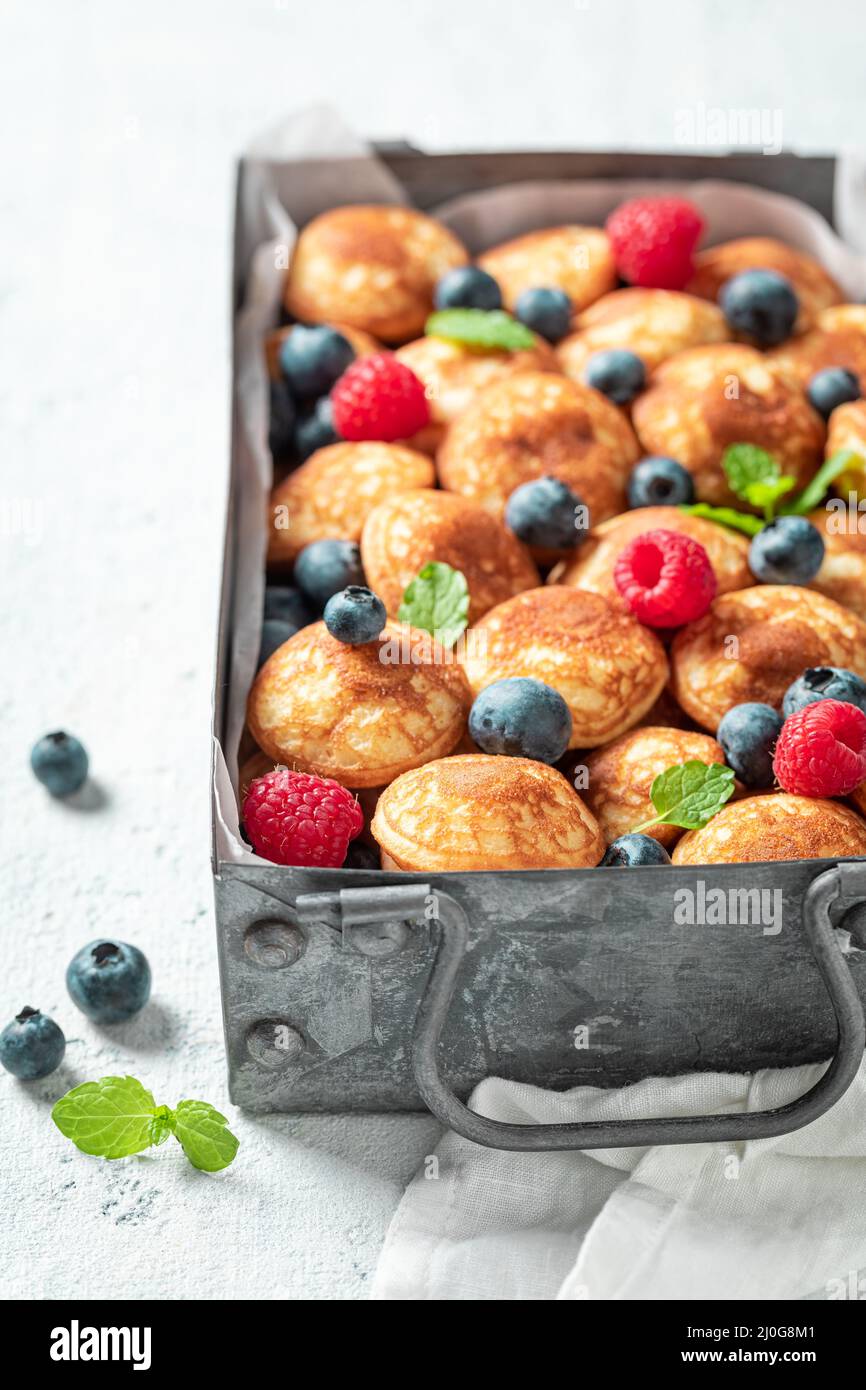 Homemade and fresh poffertjes with sweet fruits. Breakfast with mini ...