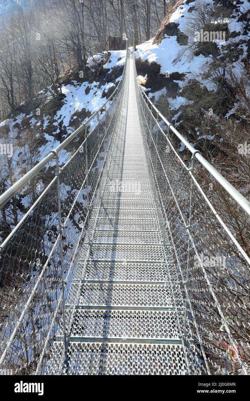very long suspension bridge in stainless steel without people in winter ...