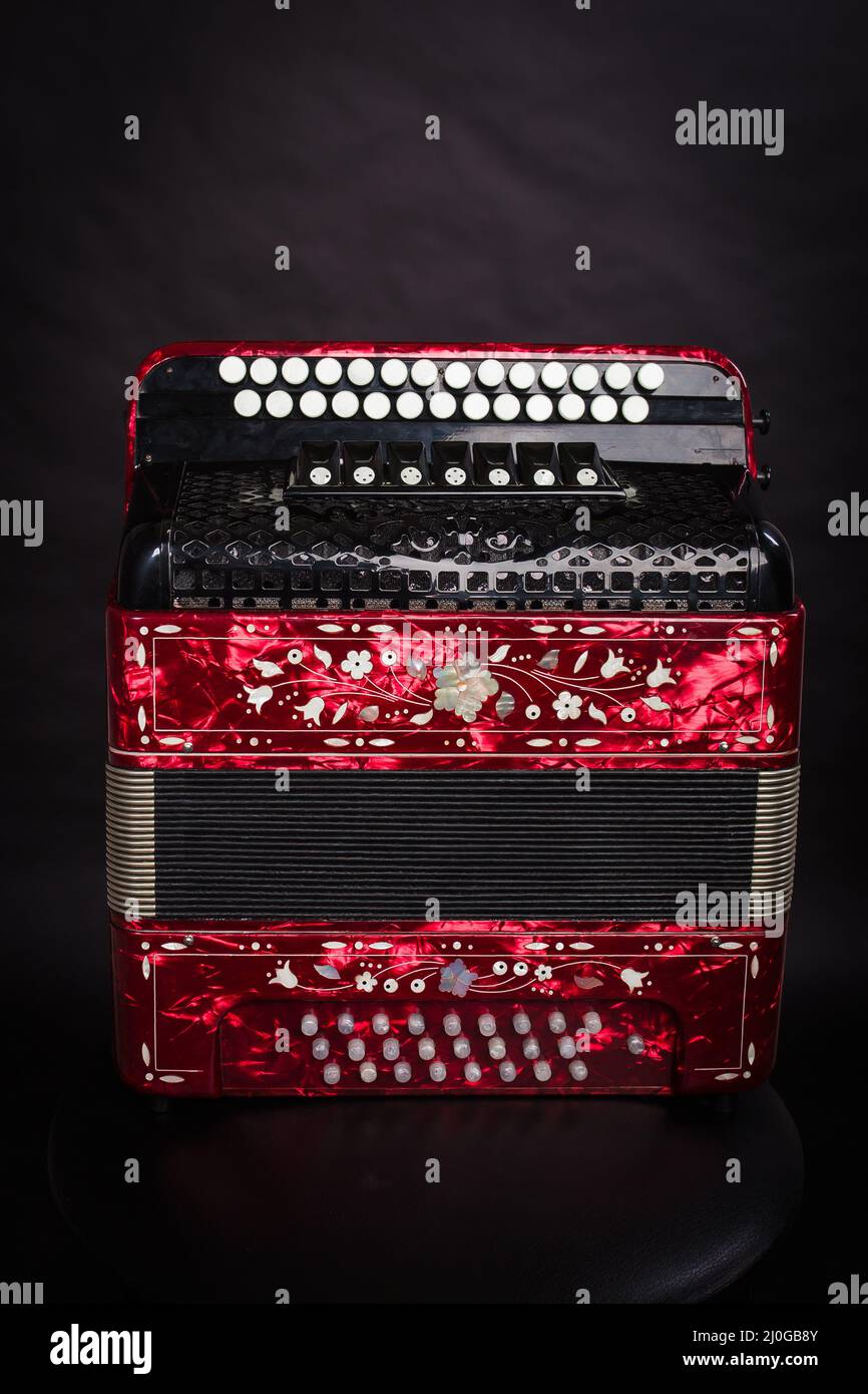 Russian folk instruments.Red bayan on a black background.Russian ...