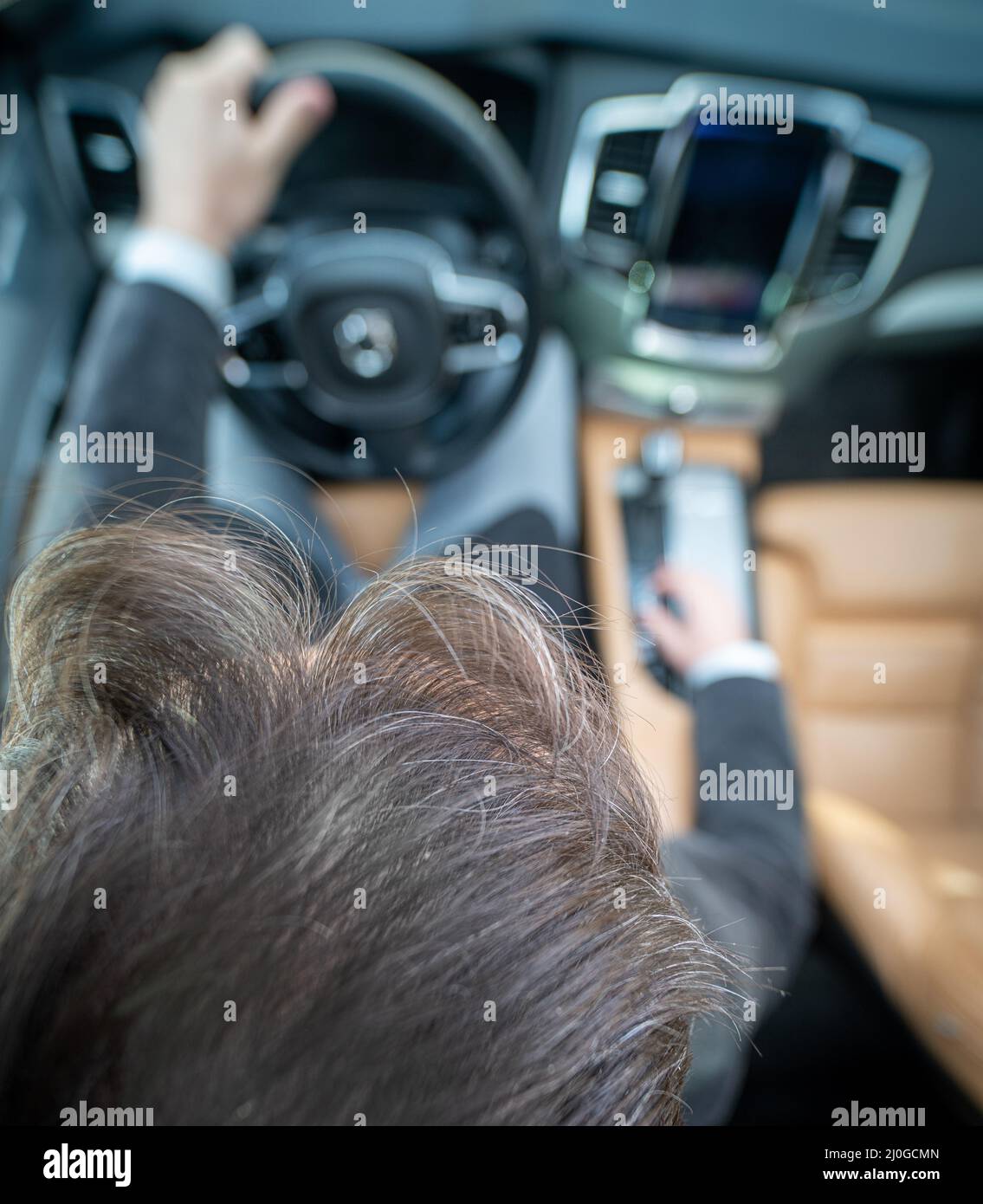 Wide angle of a male driver in luxury car Stock Photo - Alamy