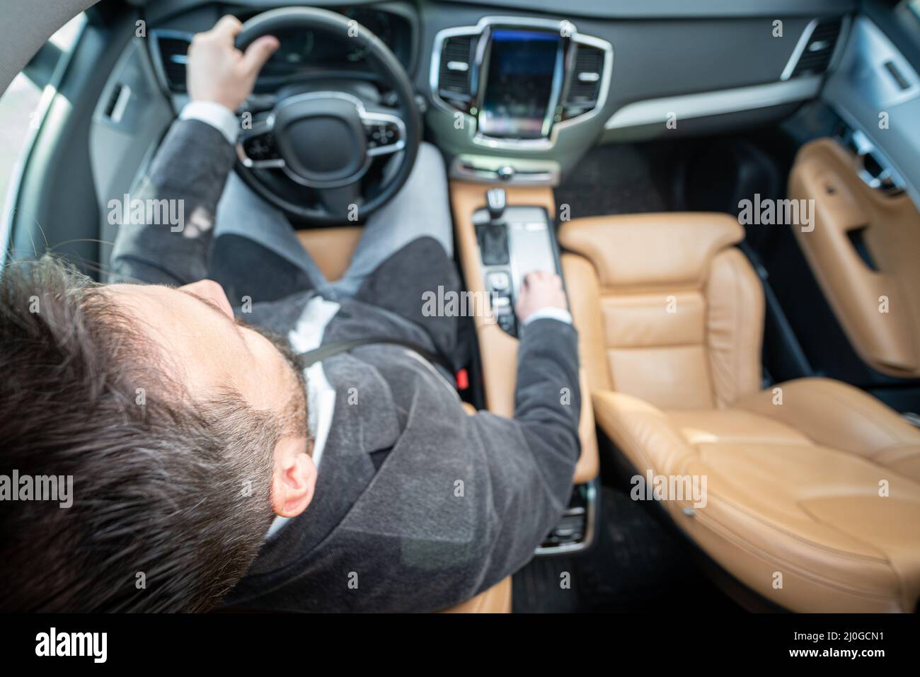 Wide angle of a male driver in luxury car Stock Photo - Alamy