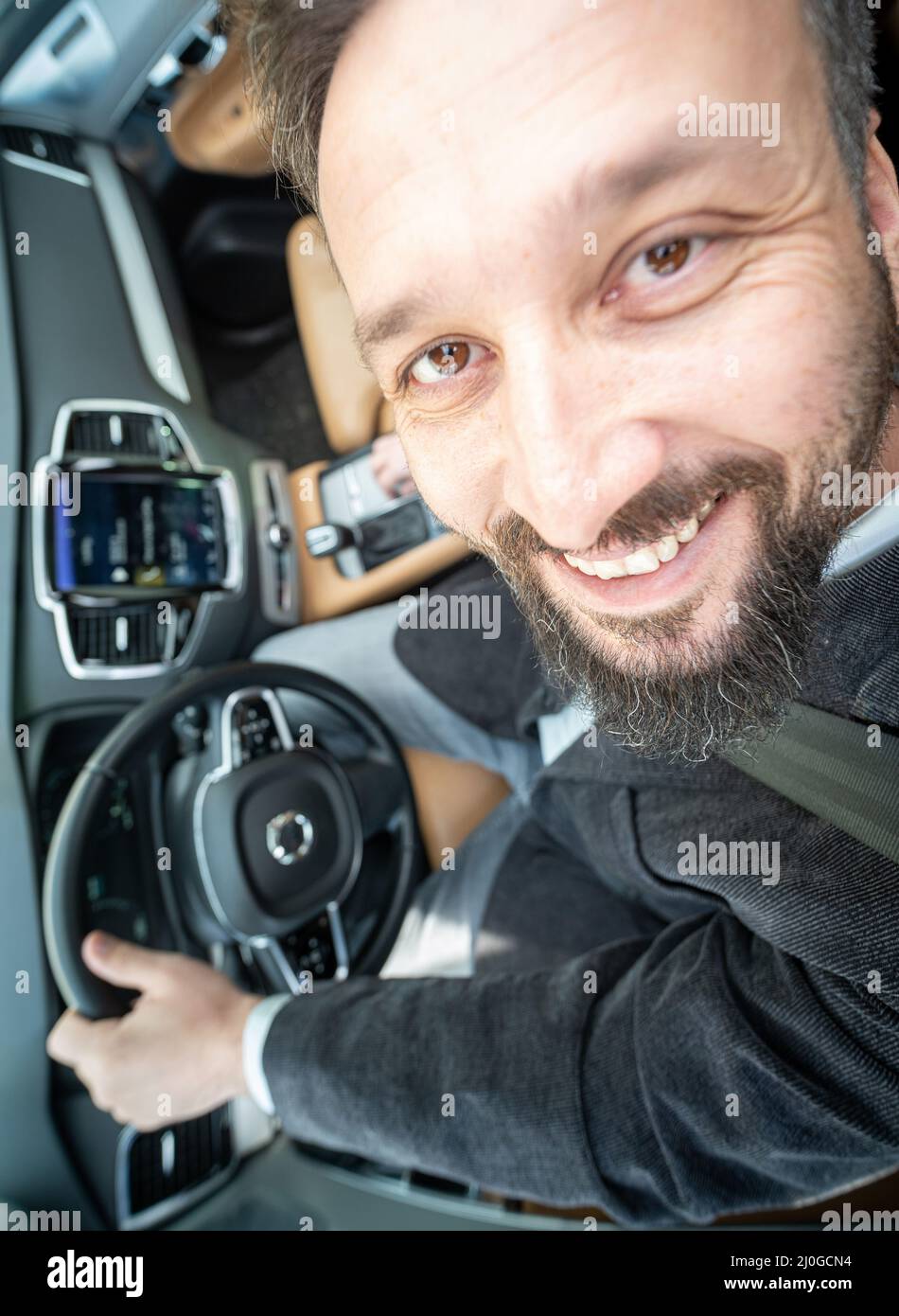 Wide angle of a male driver in luxury car Stock Photo - Alamy
