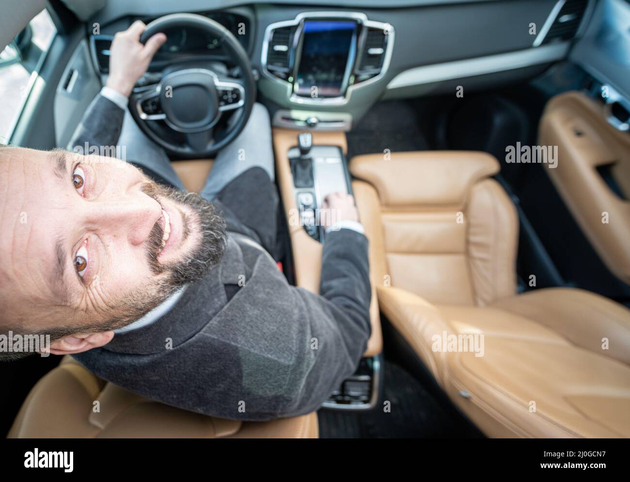 Wide angle of a male driver in luxury car Stock Photo - Alamy