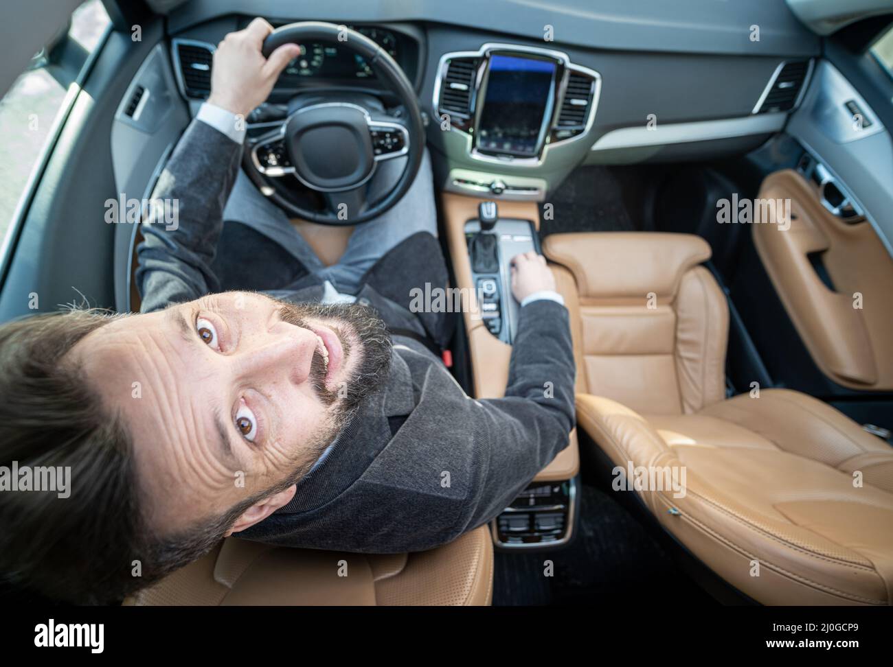 Wide angle of a male driver in luxury car Stock Photo - Alamy
