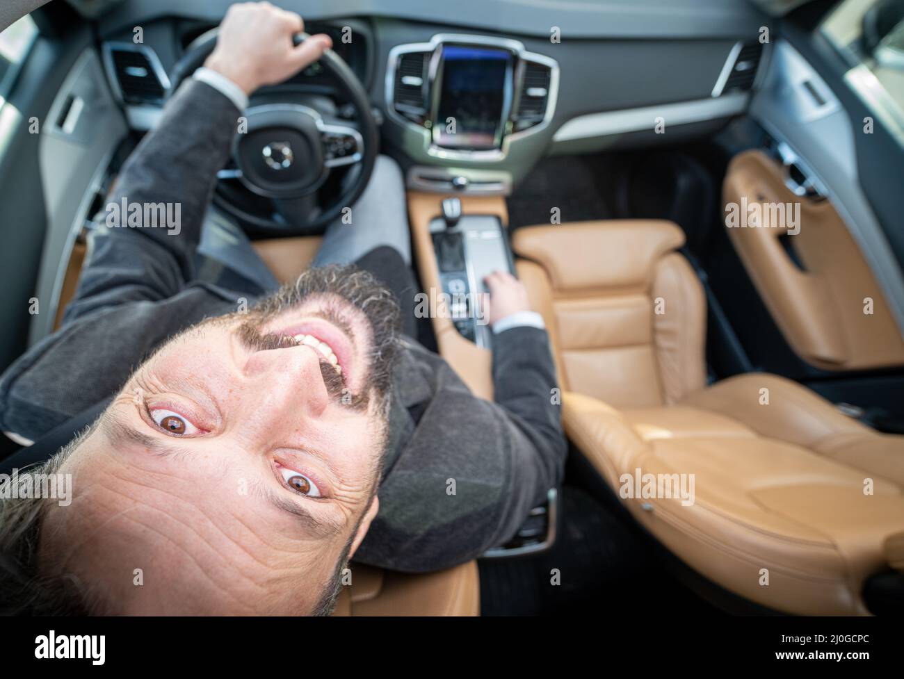 Wide angle of a male driver in luxury car Stock Photo - Alamy