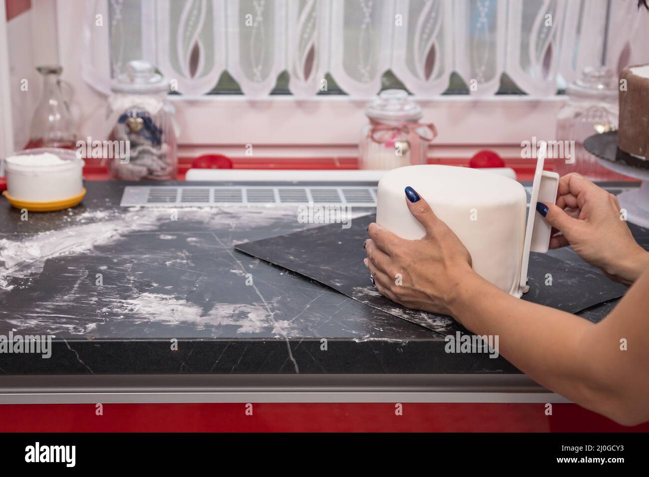 Photo of woman making beautiful custom cake Stock Photo - Alamy