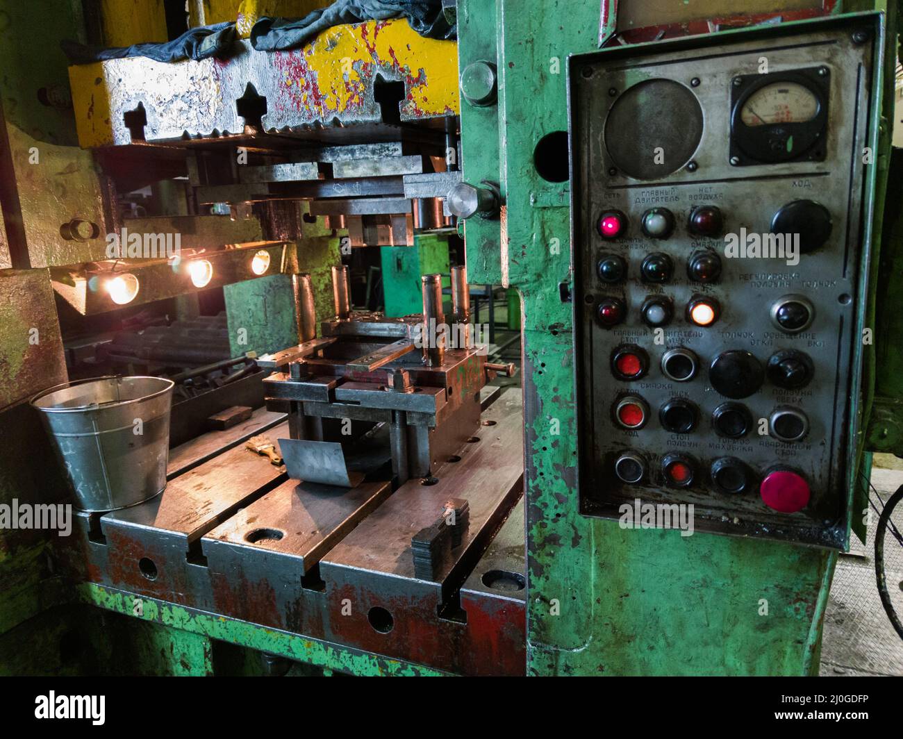 dirty used low tech stamping press in dark environment with large ...