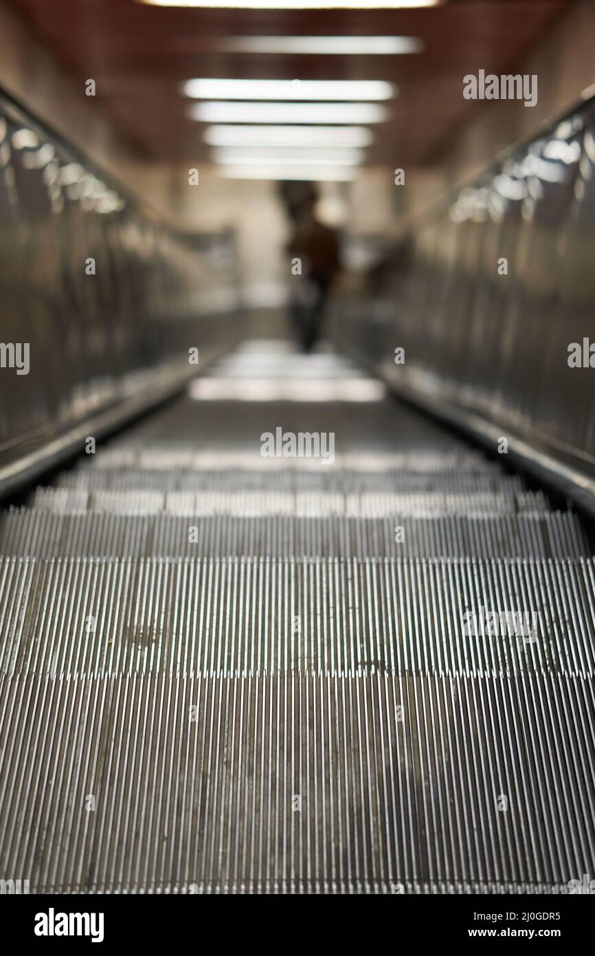 Vertical closeup of an escalator upper steps with the balustrades and a ...