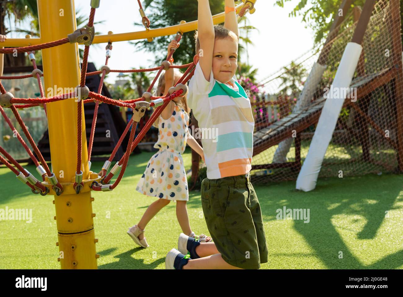on a sunny summer day, a european boy rides a carousel made of climbing ...