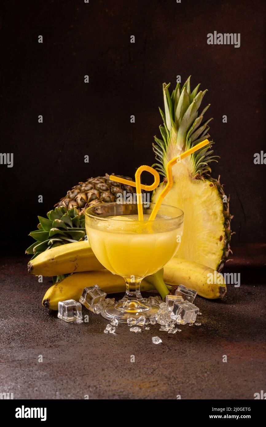 Delicious cold refreshing ananas smoothie drink in cocktail glass with ...